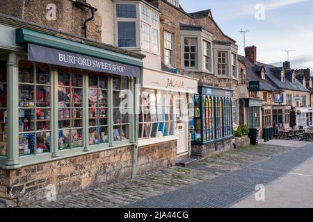 A row of traditional old shop fronts, signs and along town centre ...
