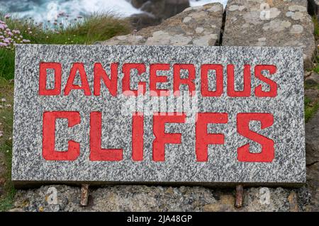 Dangerous cliffs sign in red writing and a flat marble slab Stock Photo ...