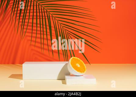 A drink party scene with a fresh grapefruit on a pink background ...