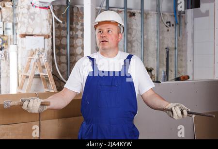 Perplexed worker inspecting room Stock Photo - Alamy