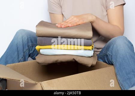 Donation concept with clothes on white wooden background Stock Photo ...