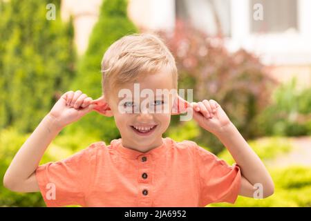 five-year-old boy making faces. A five-year-old blond boy makes faces ...