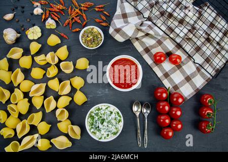 Stuffed conchiglie preparation, food ingredients and female hands on ...