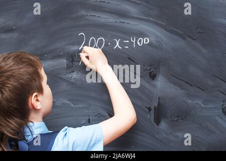 The student solves a math problem standing at the blackboard in her ...