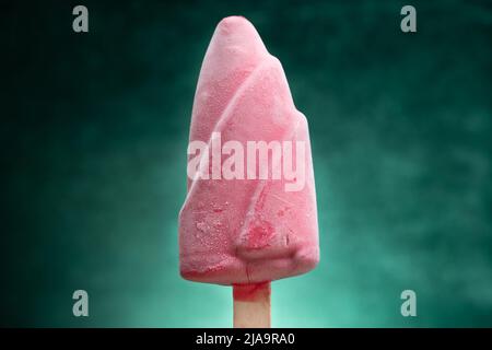 pink color chocolate outer popsicle with some bites on a gradient green ...