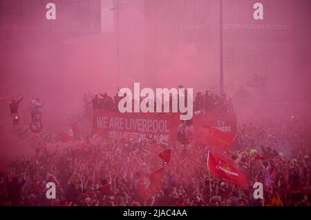 Liverpool players pass fans in their open-top bus during the trophy ...