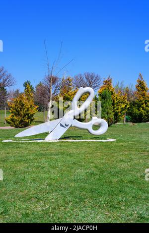 Statue of huge Scissor on the grass at park in a sunny summer day with ...