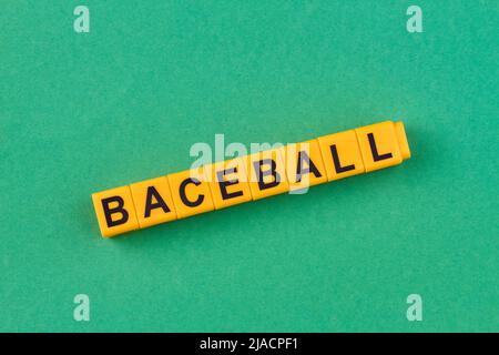 Yellow cubes with inscription baseball on green background. Space for ...