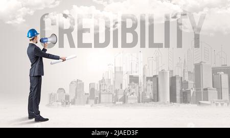 Young businessman with hard hat and CREDIBILITY inscription, new ...