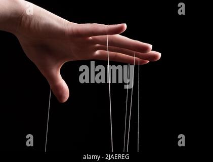 Manipulation concept. Hand of abuser manipulate on black background ...