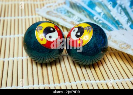 Chinese meditation balls and a fan. Baoding balls with yin-yang symbol ...