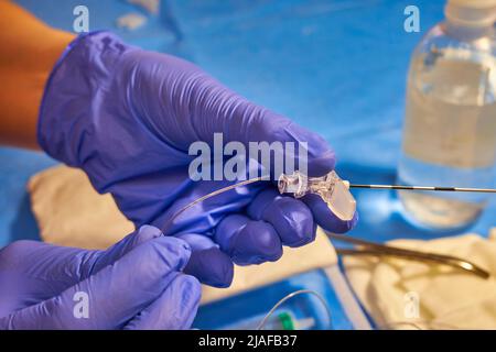Injection of spinal anesthesia in preparation for surgery. The hands of ...