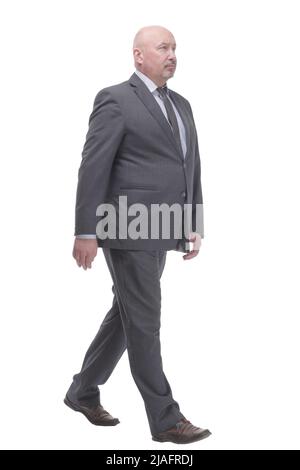 Mature business man striding forward .isolated on a white background ...