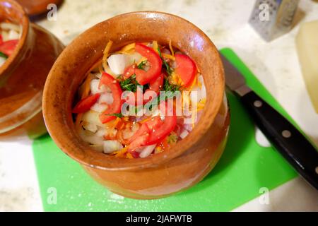 Preparing a dish for baking in a ceramic pot. Delicious DIY food at ...