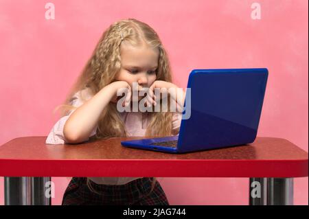 sad, brooding schoolgirl behind the laptop. pink background Stock Photo ...