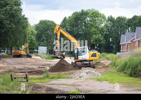 Excavators at work restoring canalized streamlet back to meandering ...