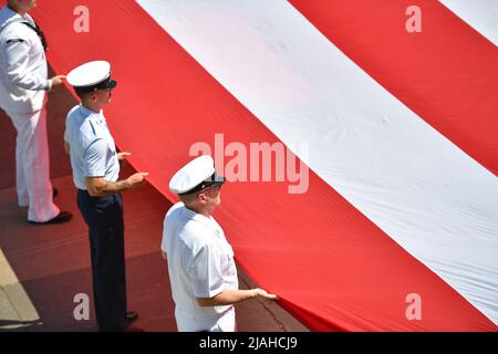 United States military personnel unroll a 100-foot American Flag during ...