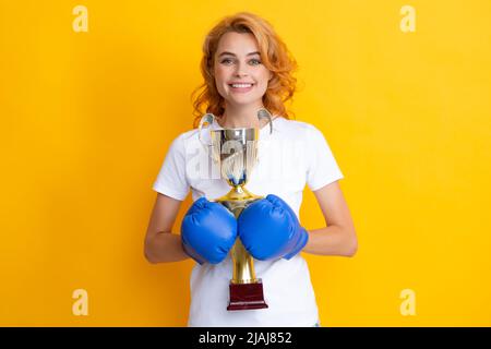 Woman in boxing gloves hold champion winner cup trophy. Funny girl in ...