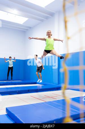 Young men are training in trampoline jumping, preparing for ...