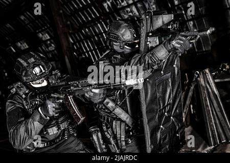 Police special reaction team aiming guns while moving forward under ...
