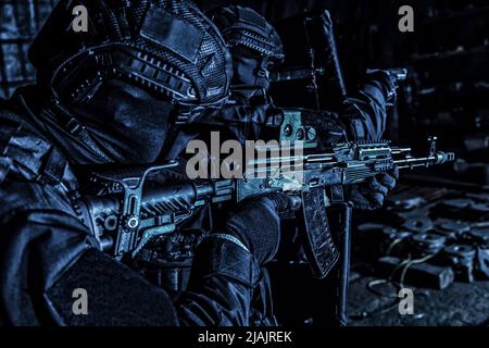 Police special reaction team aiming guns while moving forward under ...