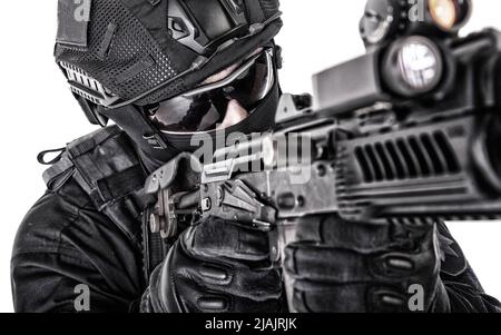 SWAT team fighter in black uniform, armed with assault rifle, studio ...