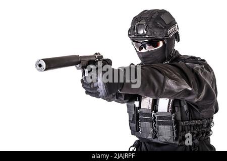 Studio portrait of SWAT officer aiming pistol with silencer on gun ...