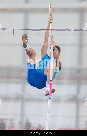 Pole vaulting indoors - young man in blue shirt running up before ...