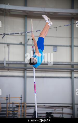 Pole vaulting indoors - young man jumping over the partition Stock ...