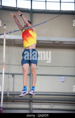 Pole vaulting indoors - a man jumping over the bar Stock Photo - Alamy