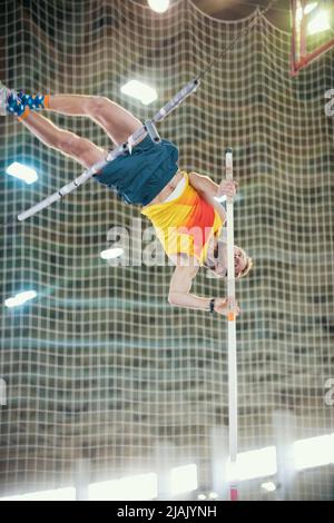 Pole vaulting indoors - a sportive man falling down after the jump ...