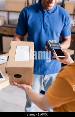 Cropped view of african american courier writing on clipboard in online ...