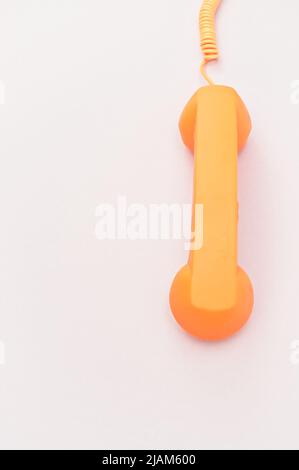 Orange corded telephone handset on blue background Stock Photo - Alamy
