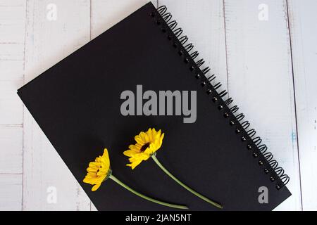 Note book flat lay with sunflowers on wooden desk. Directly above. Copy ...