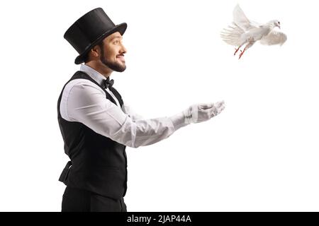 Magician performing a trick and a white dove flying from his hand ...