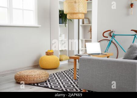 Stylish comfortable poufs and sofa in room. Home design Stock Photo - Alamy