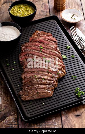 Grilled flank steak with chimichurri sauce on a grill pan Stock Photo ...