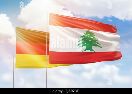 Lebanon and Germany flags waving together in the wind on blue cloudy ...