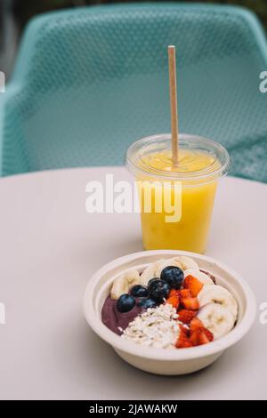 A plate of sliced fruits like an acai bowl accompanied by a natural ...