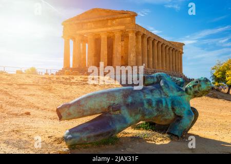 Statue of fallen Icarus in bronze in front of the 2,400 year old Temple ...