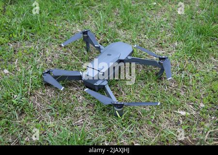 Mini drone unfolded on a grass before take-off. Small drone flies in ...