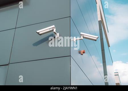 White surveillance camera built into the metal wall of the office ...