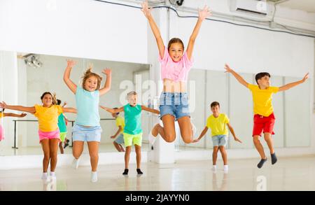 Group of cheerful tweens jumping during dances class Stock Photo - Alamy