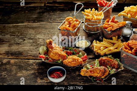 From above of fast food including delicious chicken and French fries ...