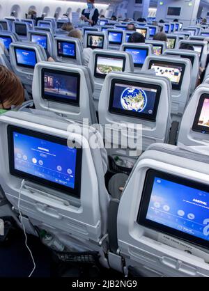 Interior of an flying aircraft with monitors on the seats Stock Photo ...