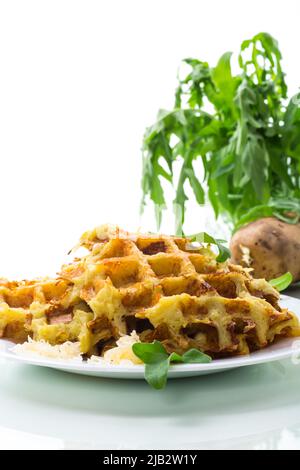 fried potato waffles with cheese in a plate on a light wooden table ...