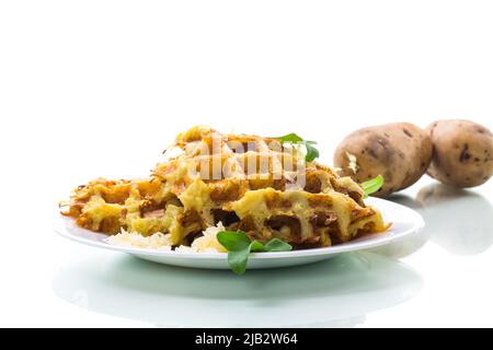 fried potato waffles with cheese in a plate on a light wooden table ...
