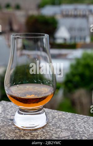 Dram of scotch whiskey with view on old houses on background, Edinburgh ...