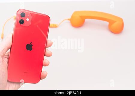 Apple iphone Product Red and old rotary phone handset on a bright desk ...