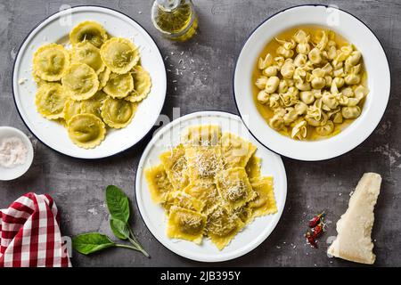 several types of boiled italian ravioli in plates on the table ...